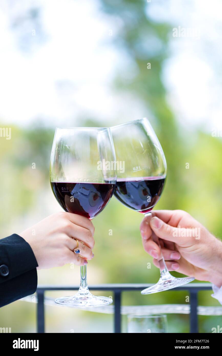 Clink With Red Wine Glasses Outside On The Terrace In A Fine Dining