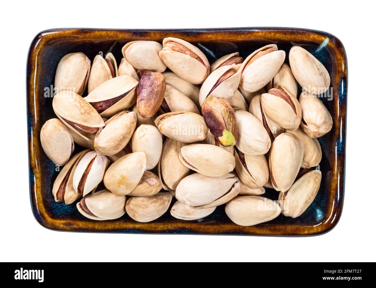top view of peeled and unpeeled Pistachio nuts in bowl cutout on white ...