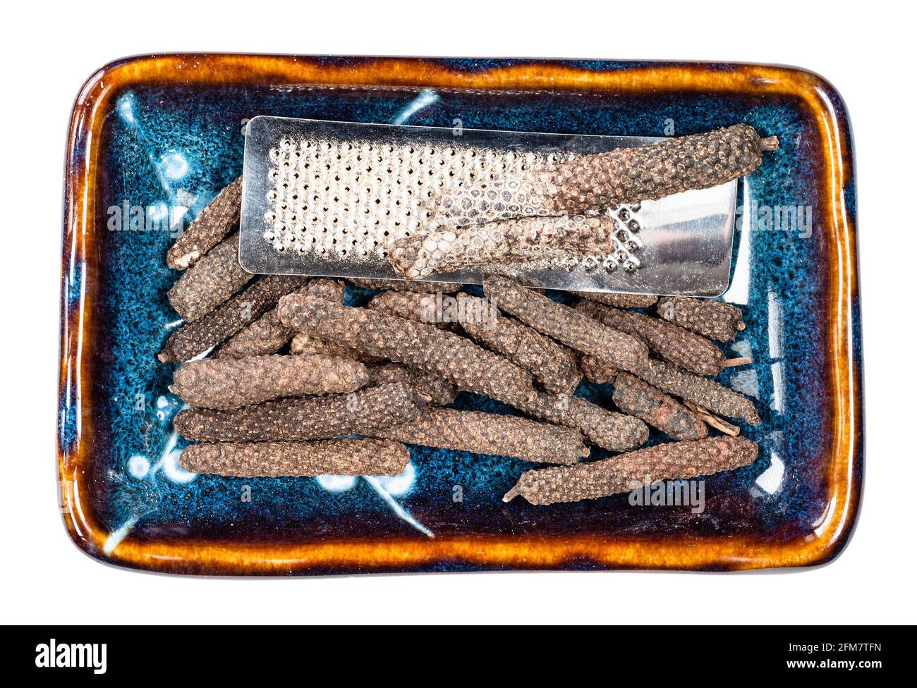 top view of java long pepper catkins and grater in ceramic bowl cutout ...