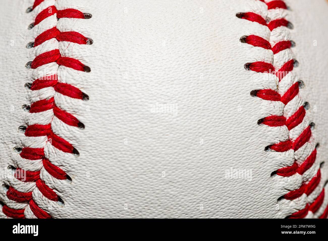A macro of a baseball with red stitching and room for copy on the ball ...