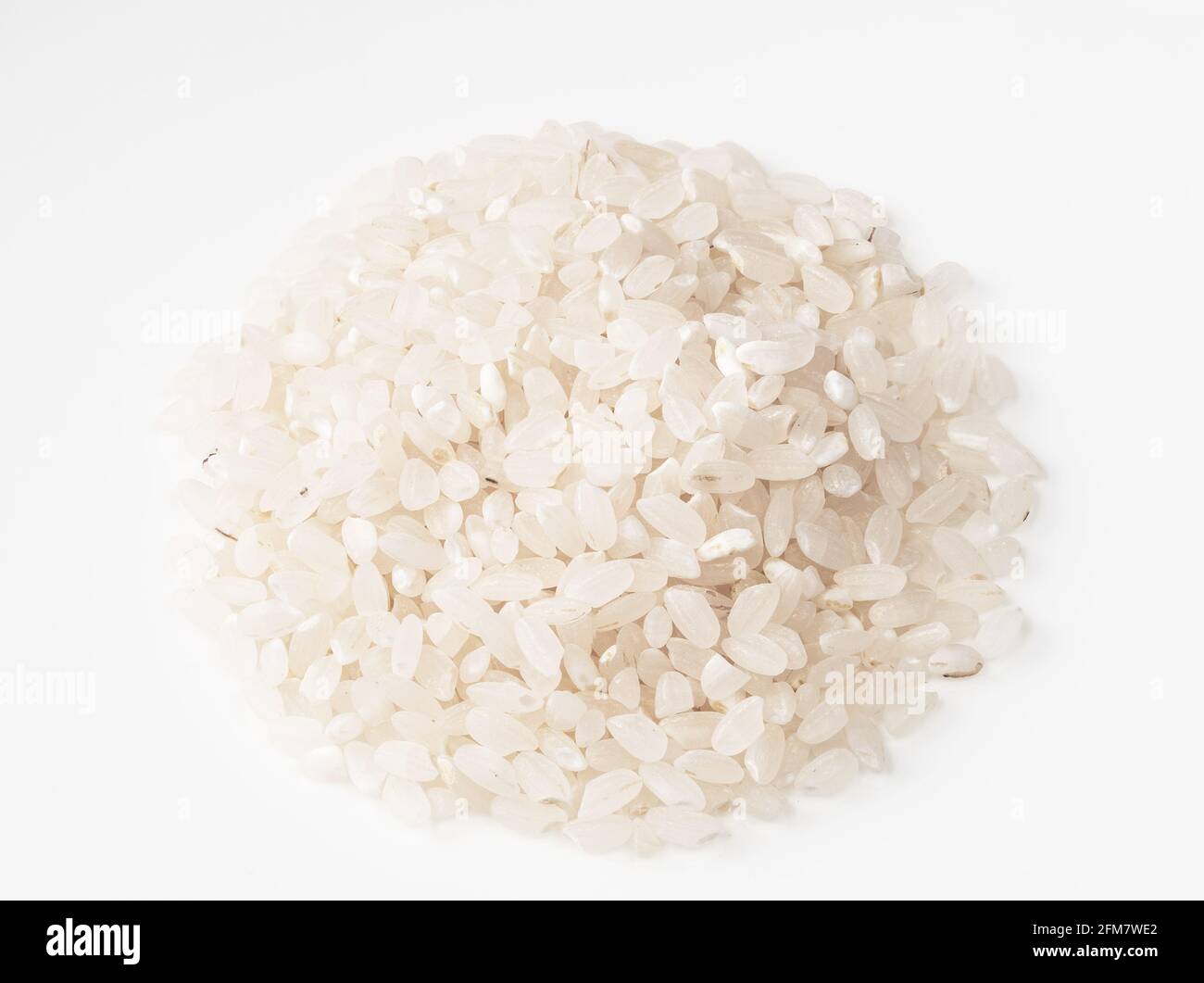 pile of raw medium-grain polished rice closeup on white background ...
