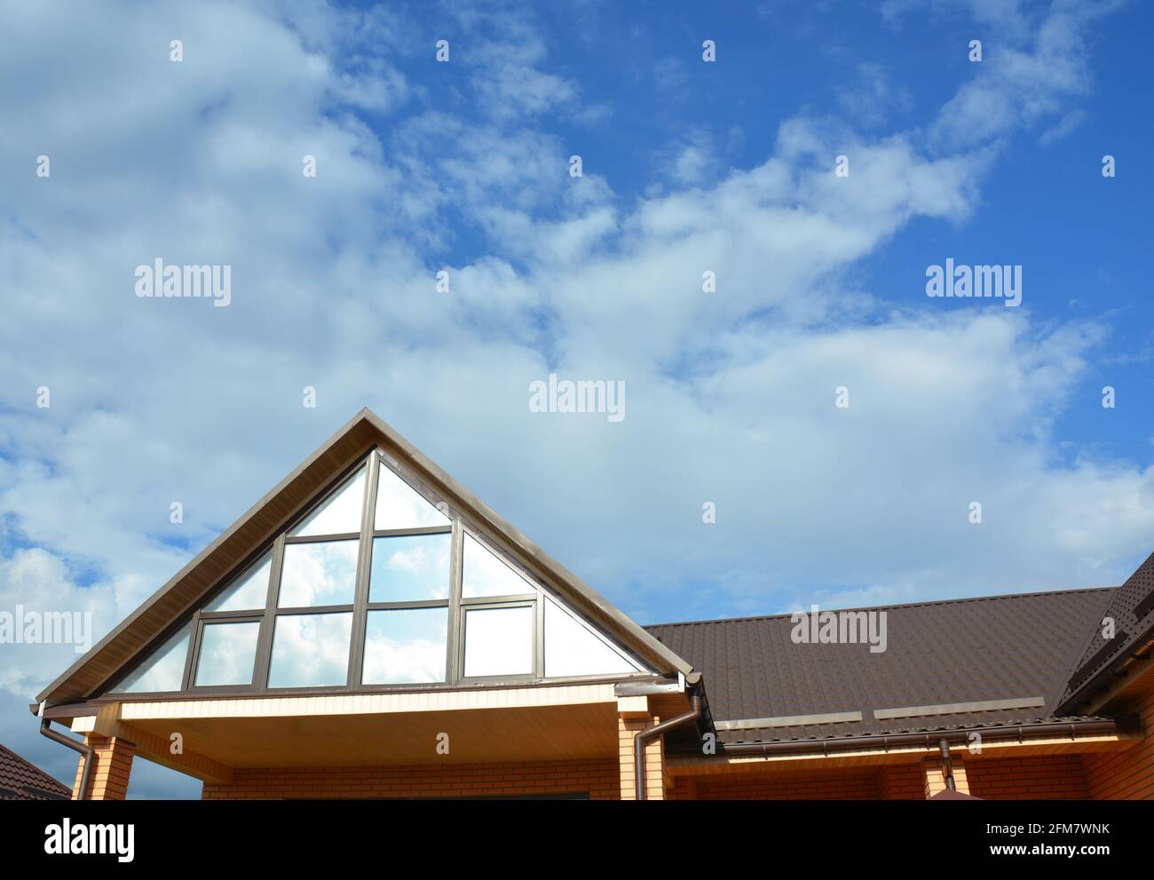 A modern house with an attic panoramic triangular window or attic ...