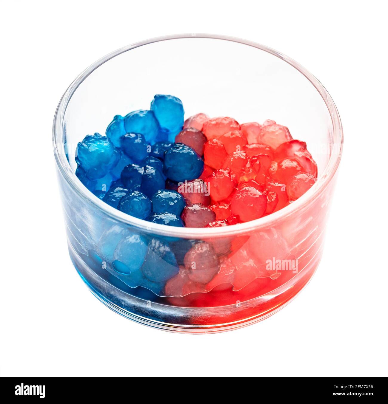 red and blue colored boiled tapioca balls in glass bowl cutout on white ...
