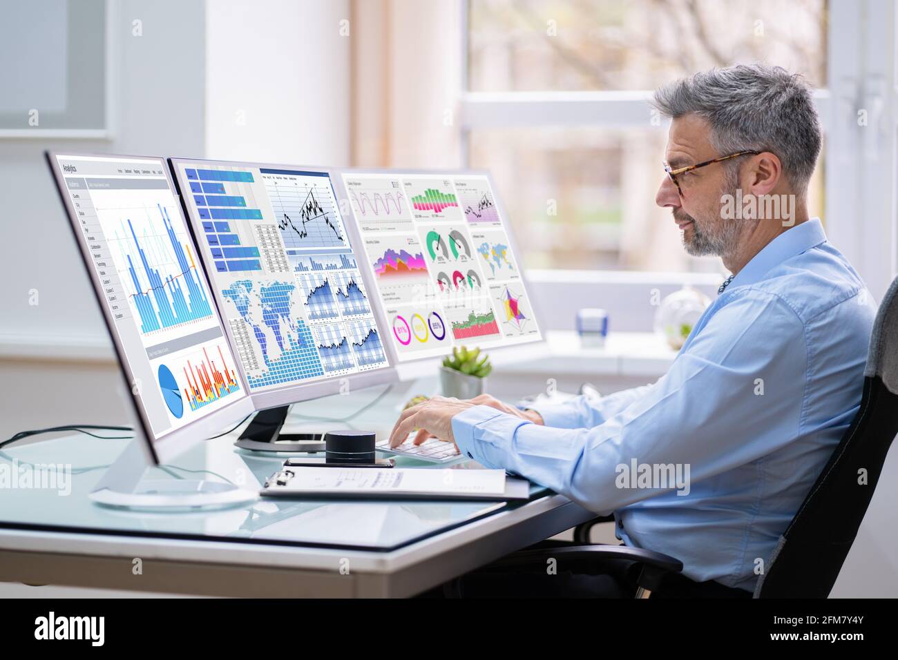 Man Advisor Using Multiple Computer Monitors With Finance Charts Stock ...