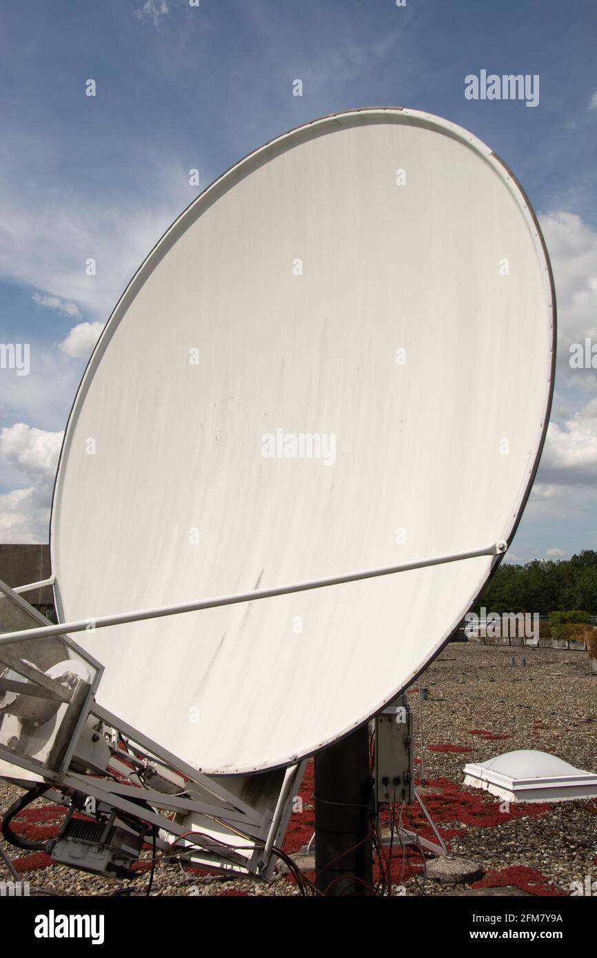 dirty old satellite dish on flat roof in front of blue sky Stock Photo ...