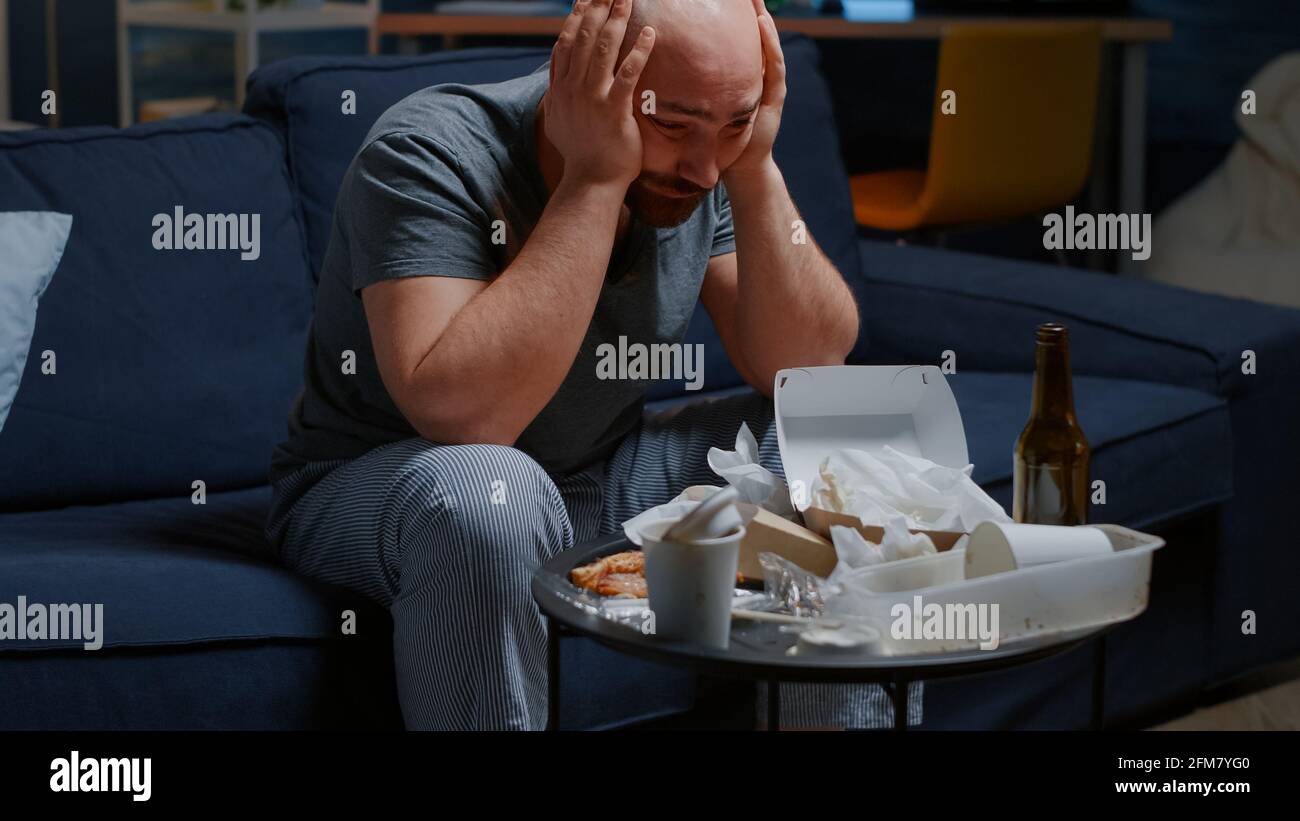 Sad depressed man sitting on couch desperately fatigue loneliness ...