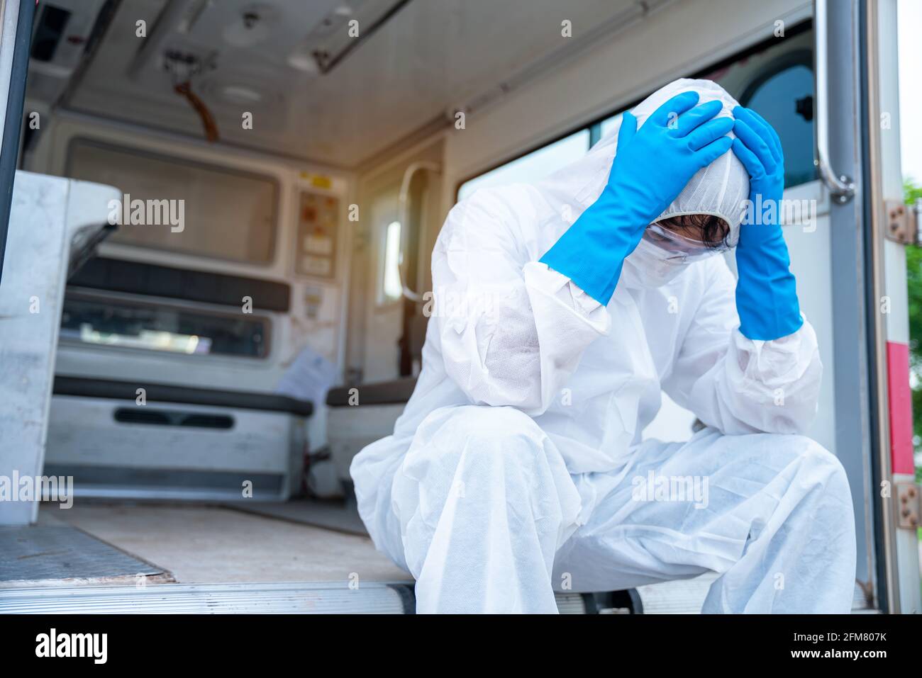 Frontline doctor or Health worker siting at an emergency ambulance Wear ...