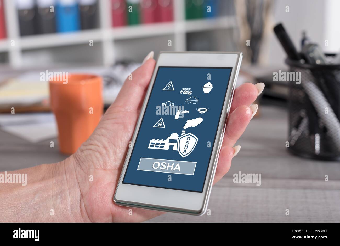 Female hand holding a smartphone with osha concept Stock Photo - Alamy