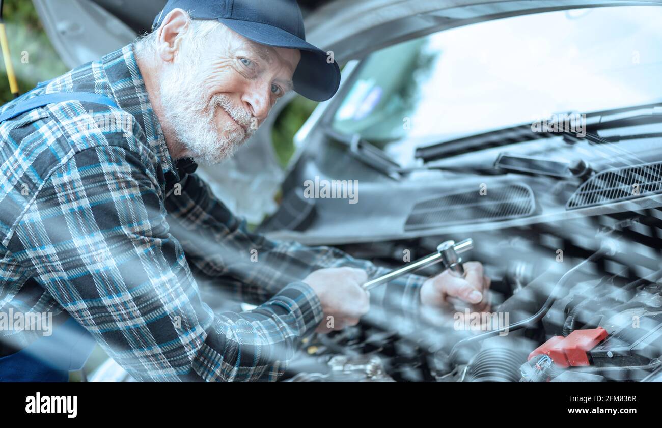 Car mechanic repairing a car engine; light effect Stock Photo - Alamy