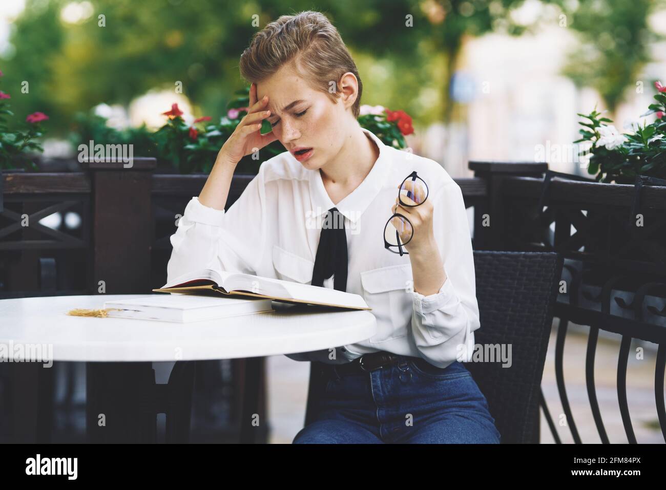 woman reading a book at a table in a restaurant education emotions ...