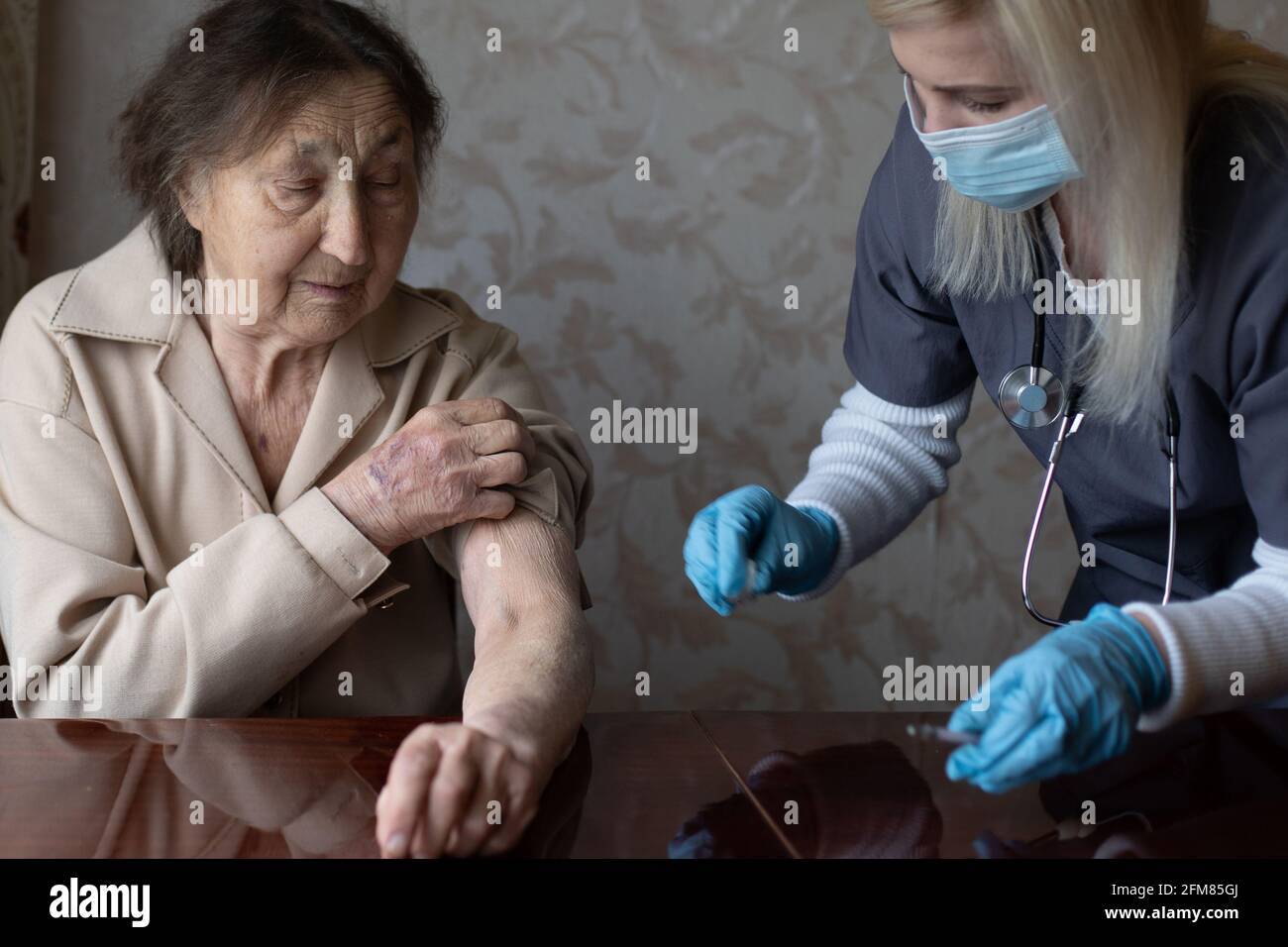 The doctor gives old woman's an injection Stock Photo - Alamy