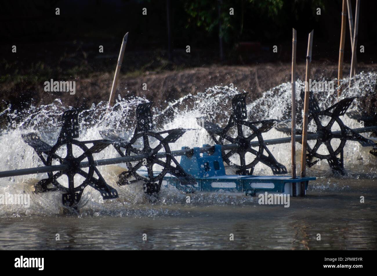 A water turbine used to rotate the water in the aquaculture pond with a ...