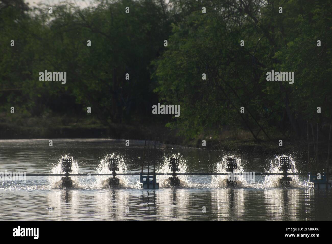 A water turbine used to rotate the water in the aquaculture pond with a ...