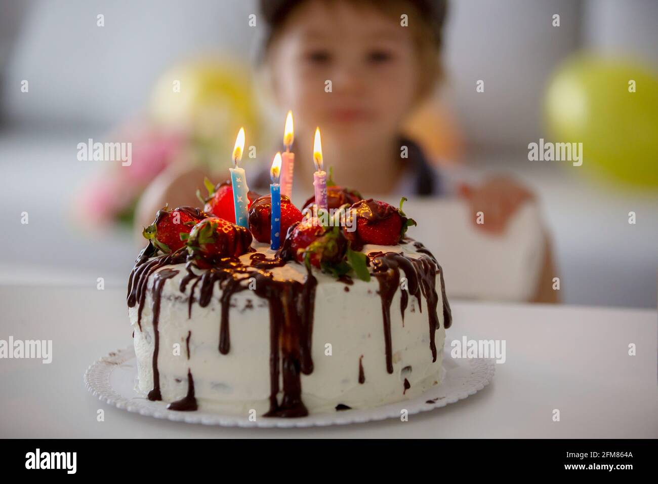 Four years old blond child, preschool boy, celebrating birthday at home ...