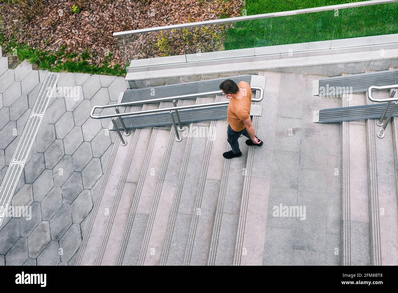 The man comes down the stairs. Concrete staircase with railings and ...