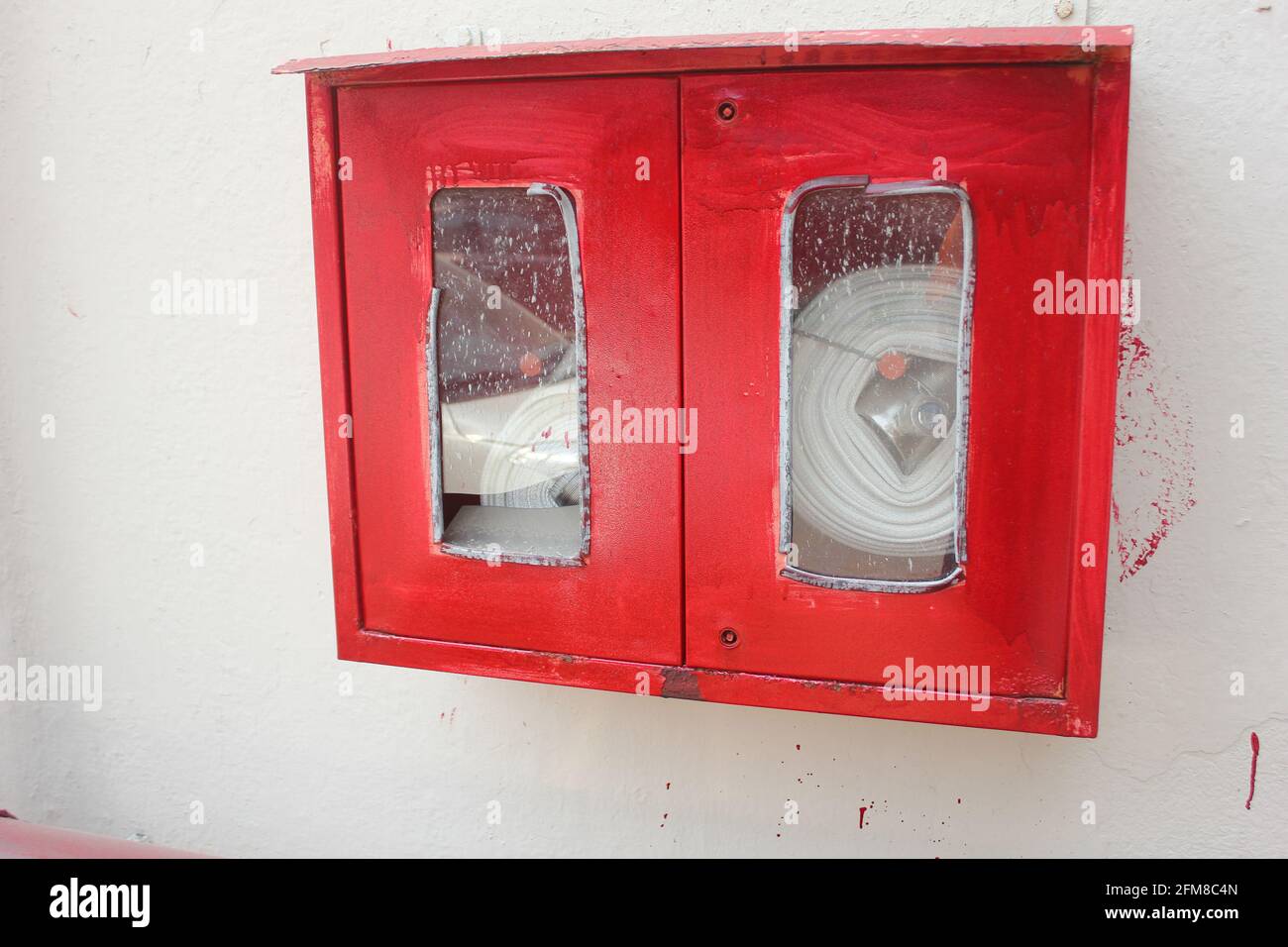 Fire-hose on the wall in a modern building Stock Photo - Alamy