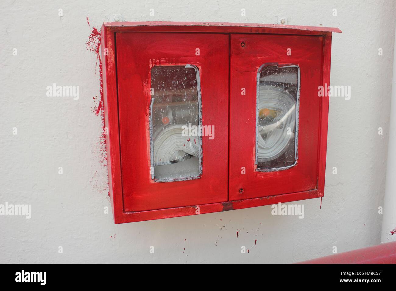 Fire-hose on the wall in a modern building Stock Photo - Alamy