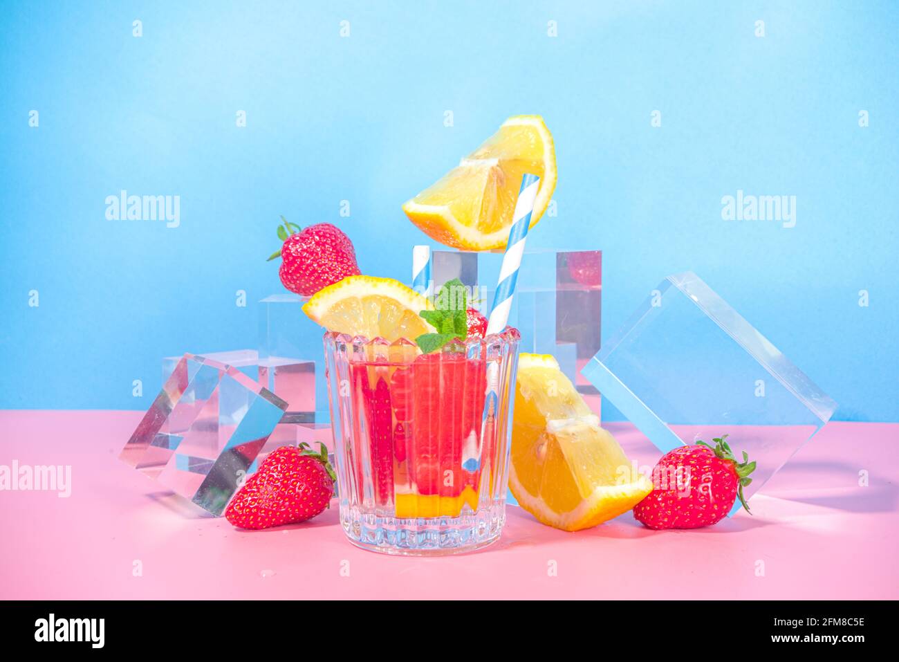 Summer bright lemonade on colorful blue pink background with glass ...