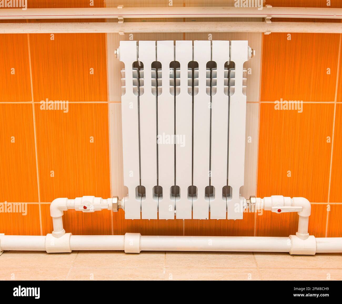 new steel radiator on the wall tiles Stock Photo - Alamy
