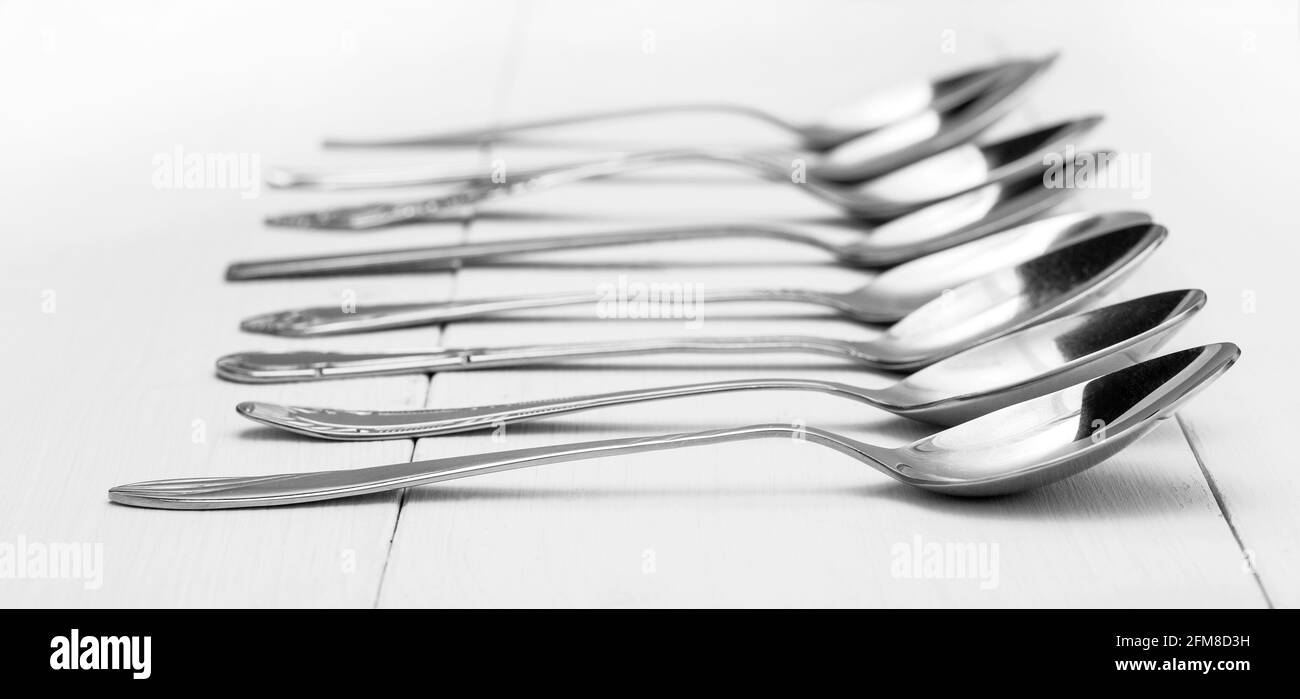 different Metal big spoon on white wooden background Stock Photo - Alamy