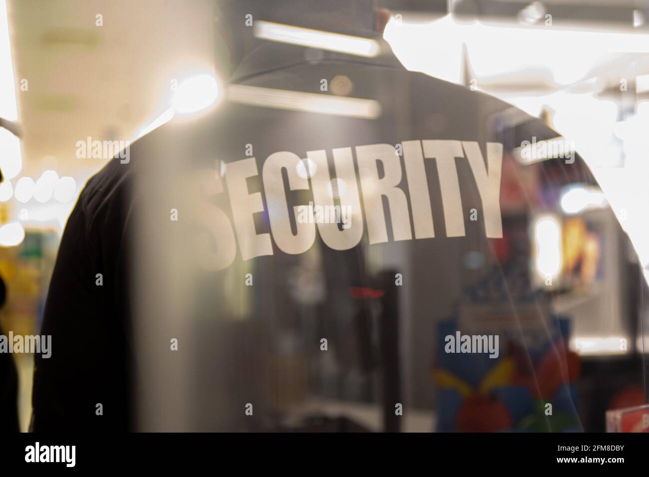 A security guard standing inside a commercial building nearby the ...