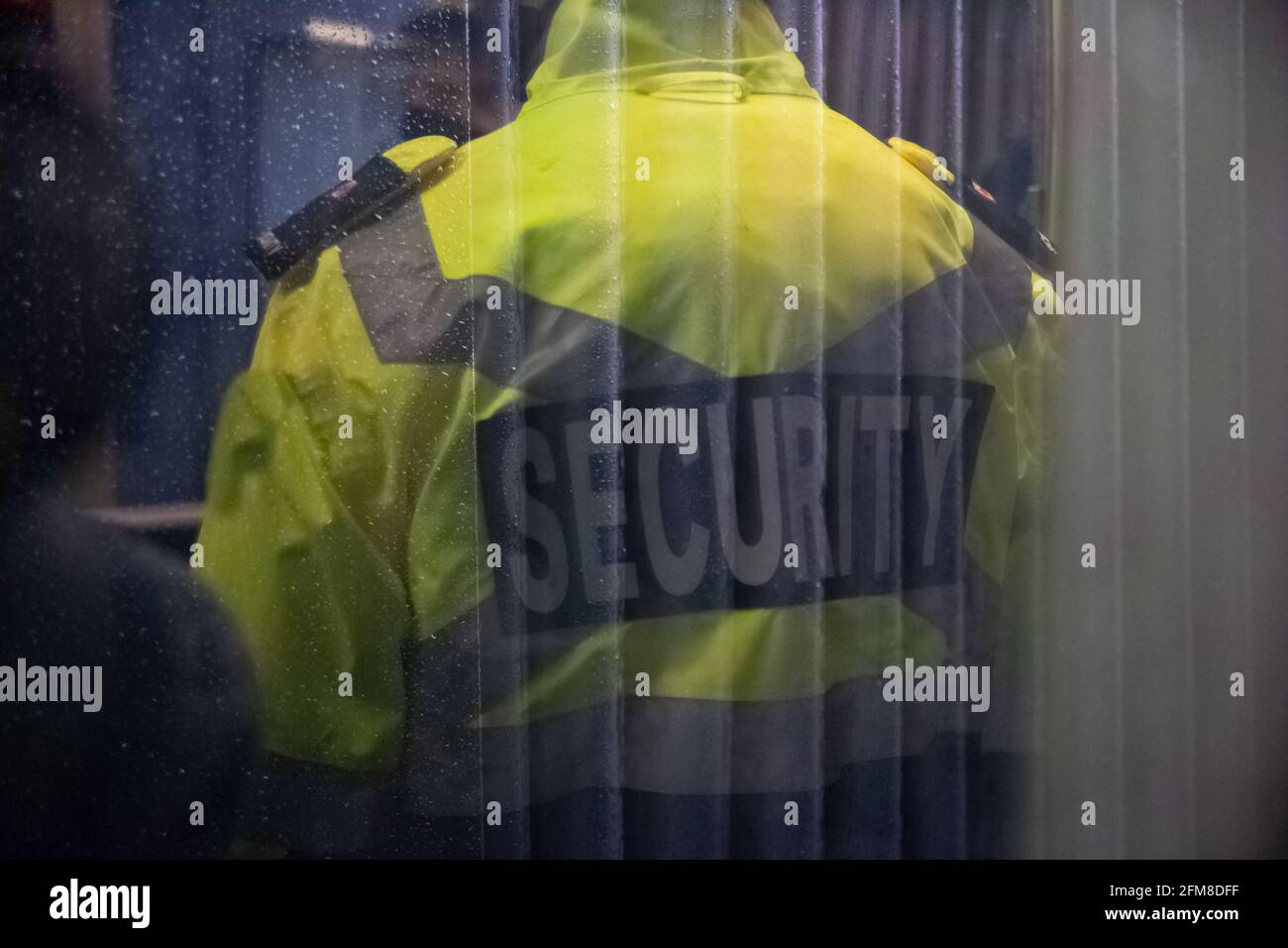 A security guard standing inside a commercial building nearby the ...