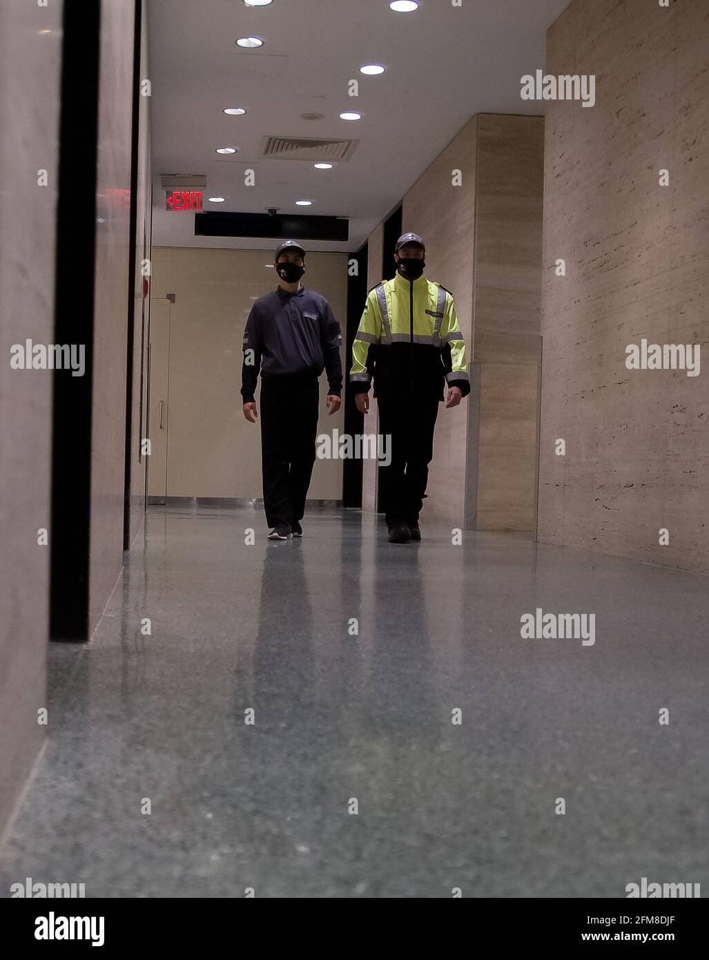 A low-angle shot of security guards patrolling inside a commercial ...