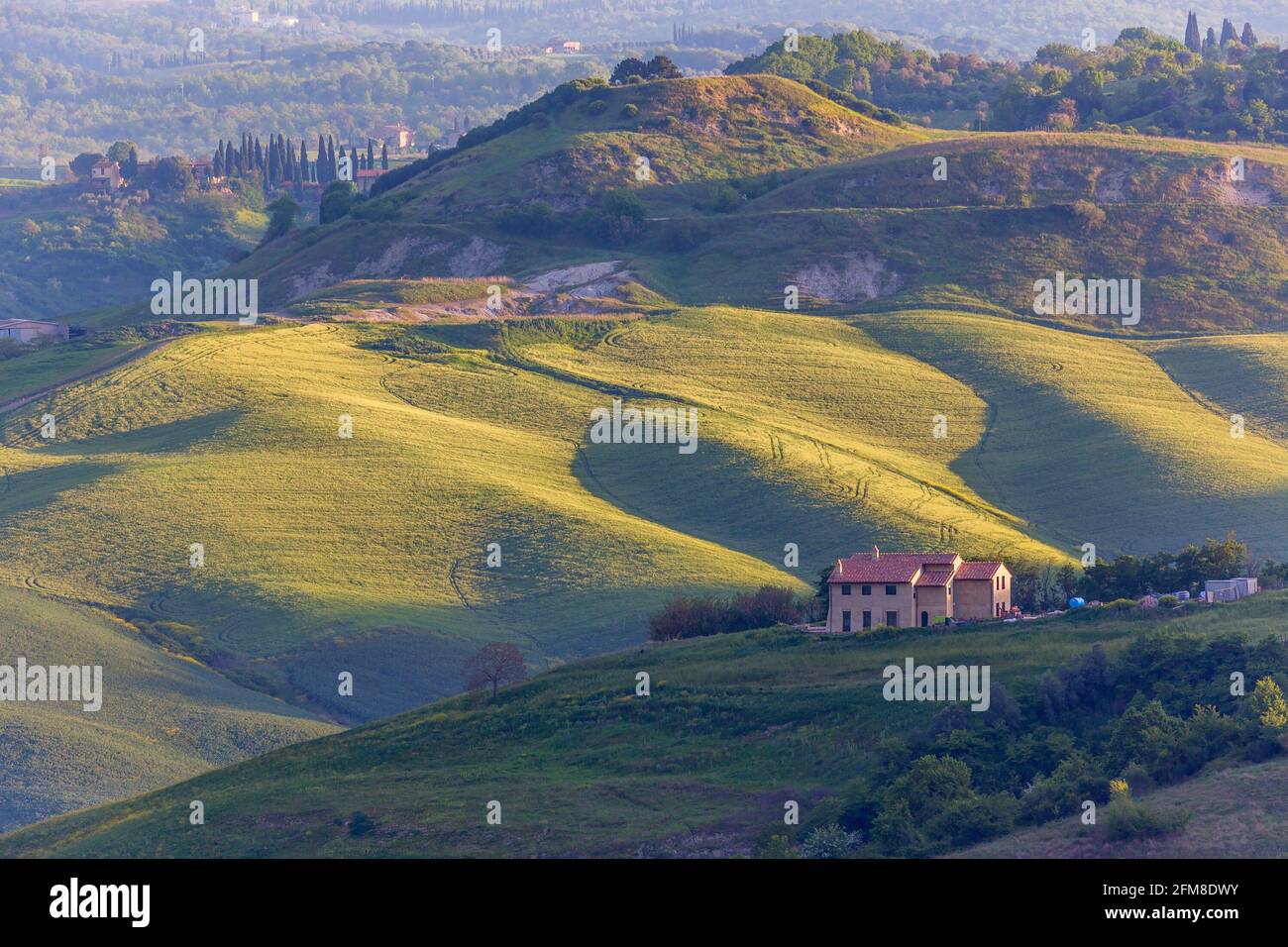 Rolling landscape with a house on slope Stock Photo - Alamy