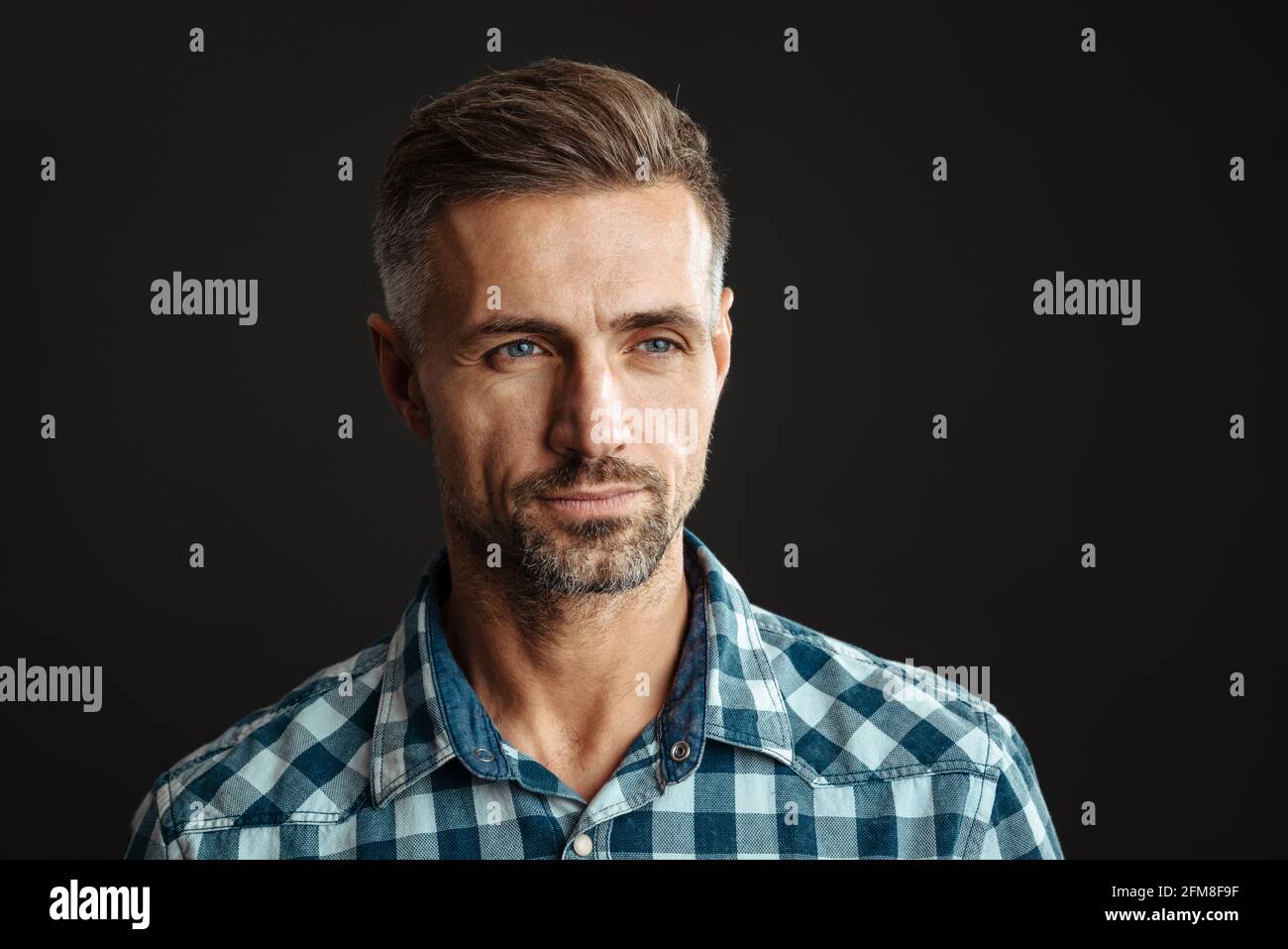 Picture of a handsome serious grey-haired man posing isolated over grey ...