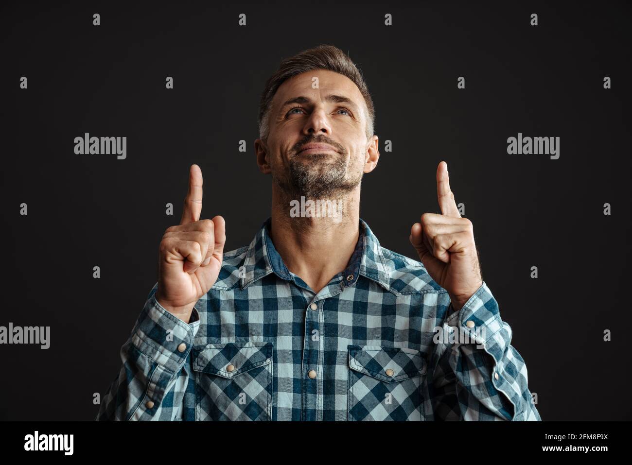 Picture of a handsome serious grey-haired man pointing isolated over ...