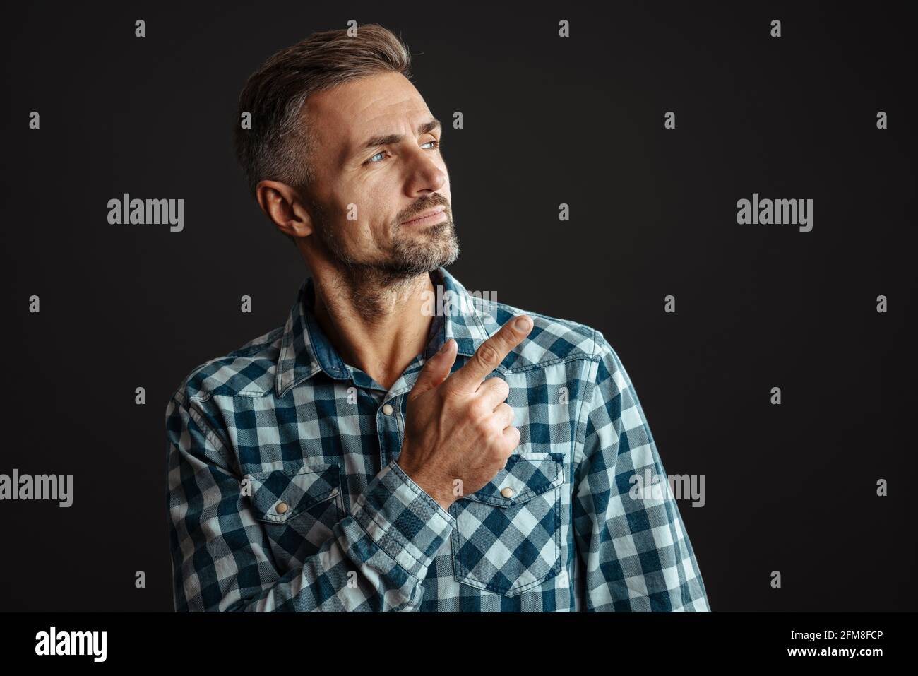 Picture of a handsome serious grey-haired man pointing isolated over ...