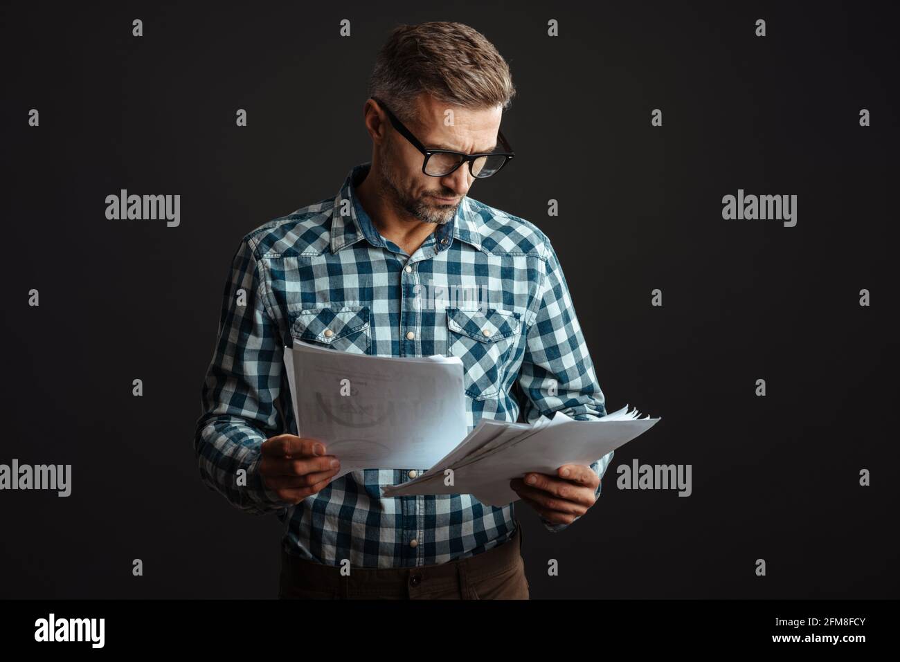 Image of a handsome serious grey-haired man holding documents isolated ...