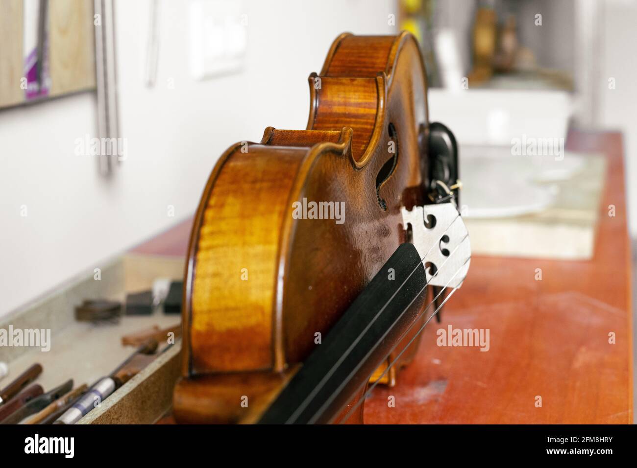Broken violin set on a dusty wooden table in the luthier's workshop ...