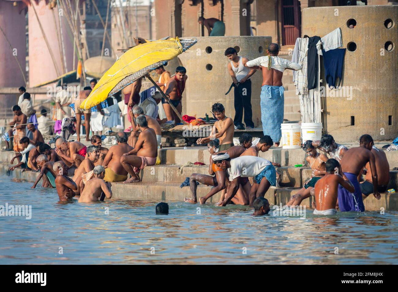Hindu devotee bathing in the Holy River Ganges at the Hindu Ghats in ...