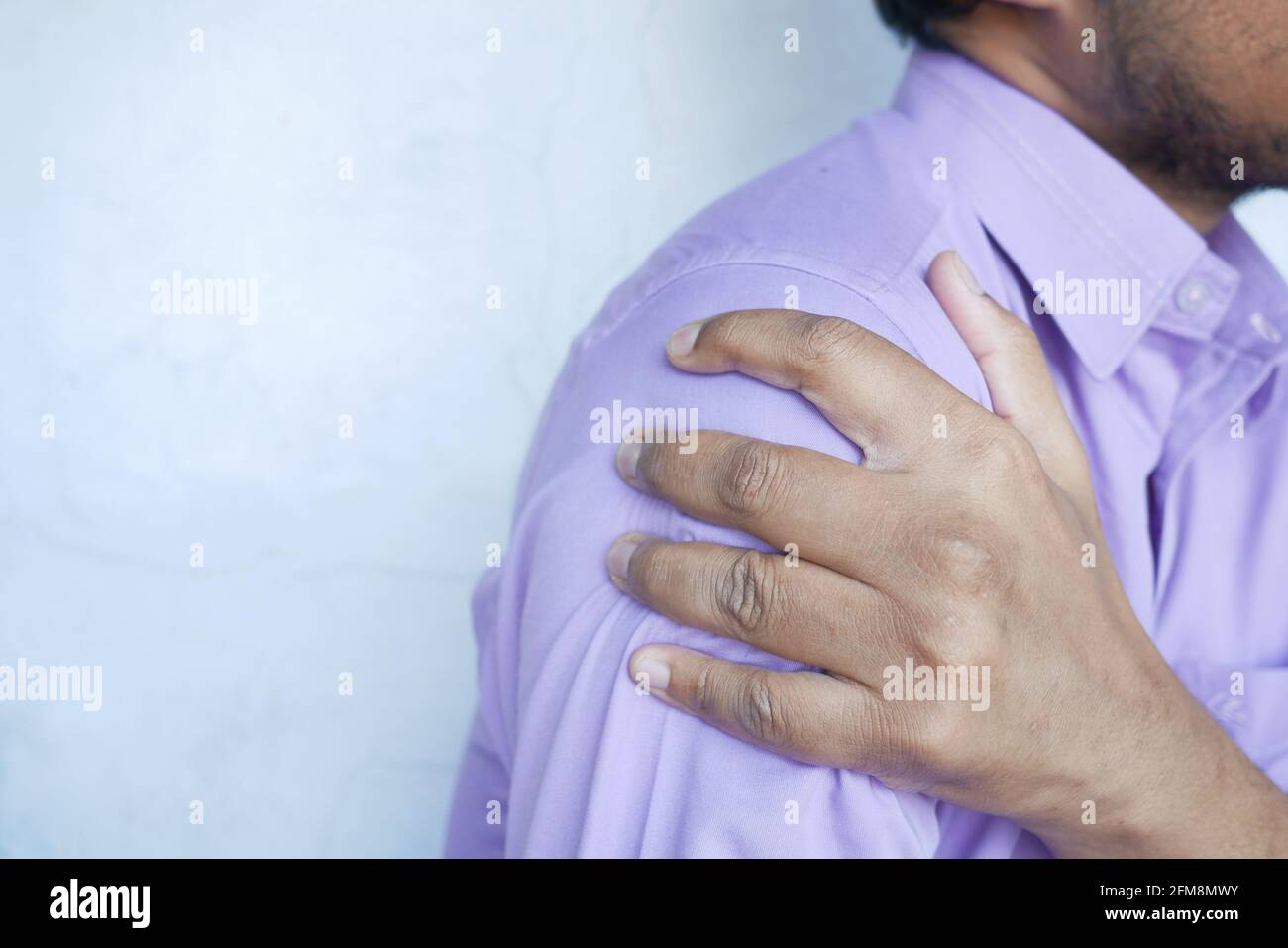 man suffering pain in shoulder close up Stock Photo - Alamy