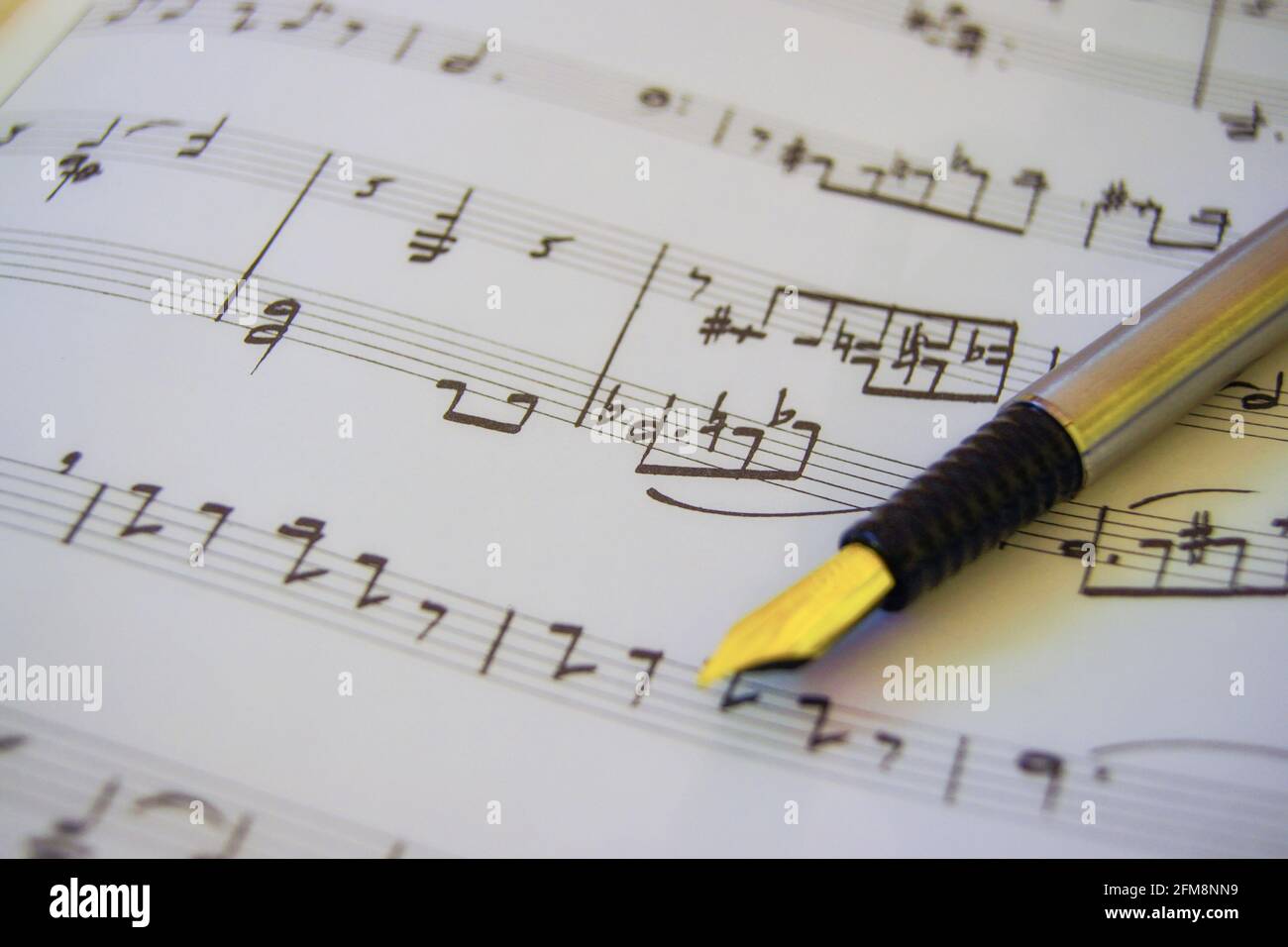 Fine gold-nibbed fountain pet set on a sheet of paper with musical ...