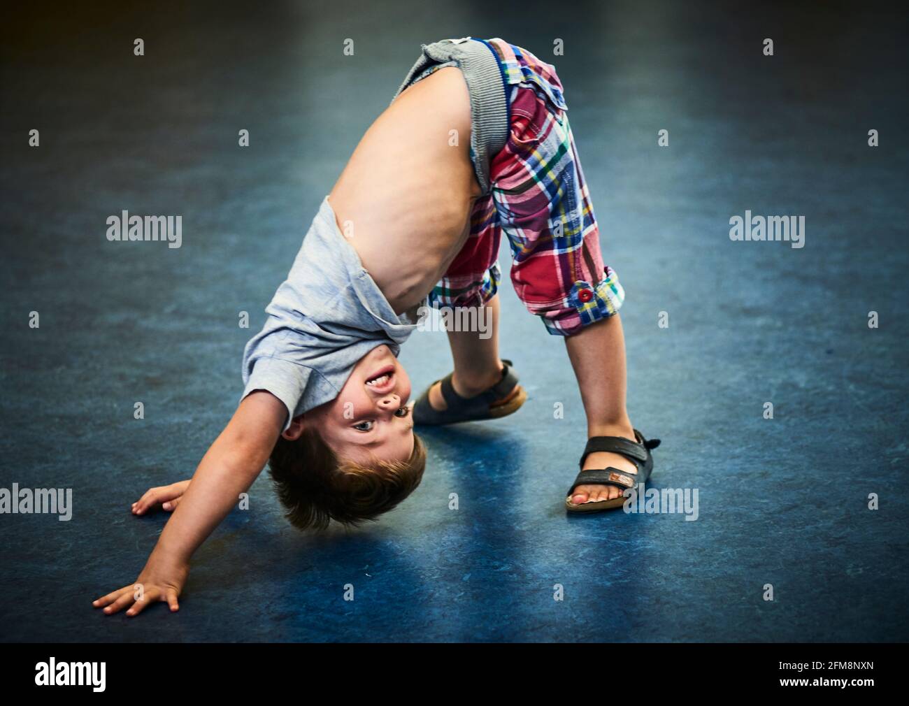 Boy in drama class bending forwards Stock Photo - Alamy