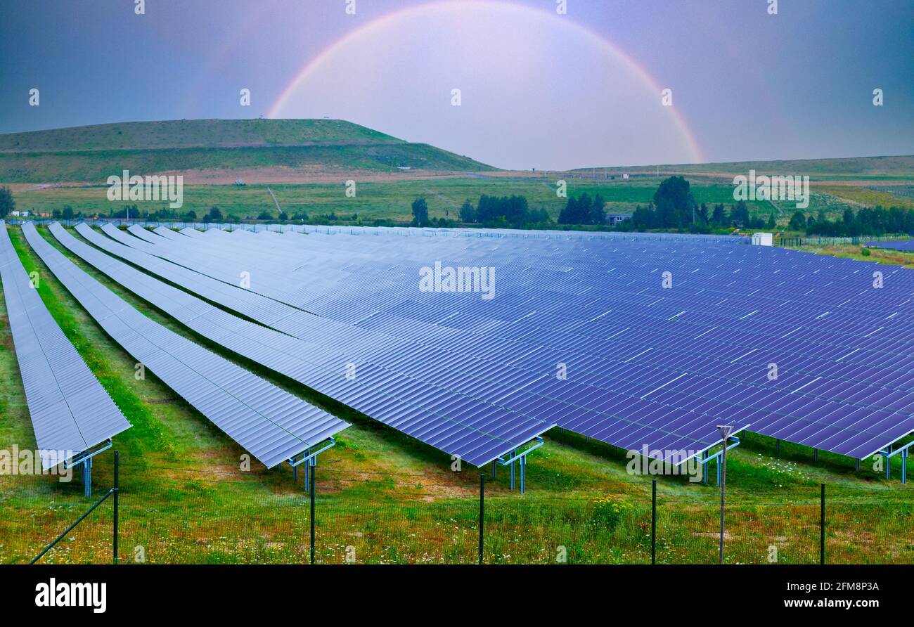 Farm with solar electric panels on a green field Stock Photo - Alamy
