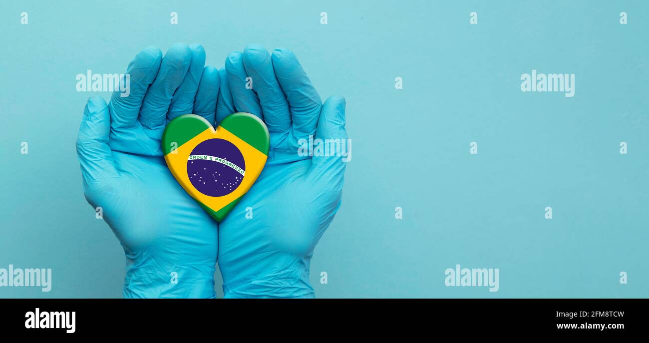 Doctors hands wearing surgical gloves holding Brazil flag heart Stock ...