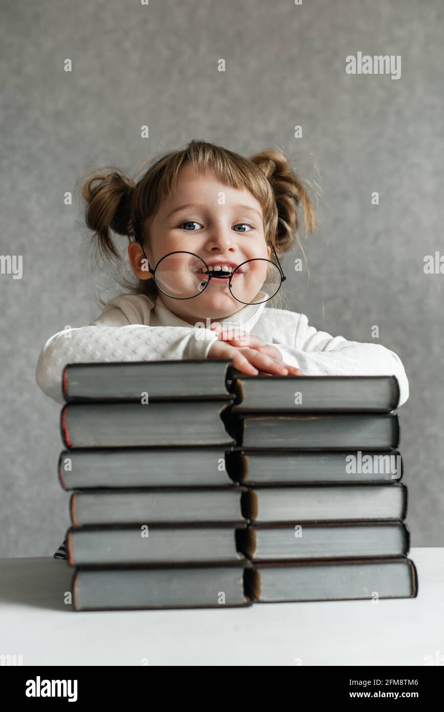 Cute kid girl preschooler with books at home Stock Photo - Alamy