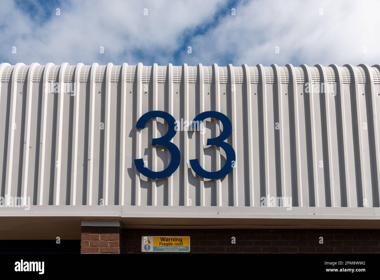 A large blue number 33 on a striped background with blue skies Stock ...