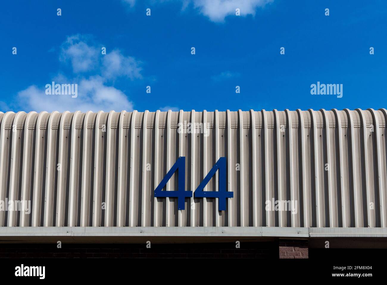 A large blue number 44 on a striped background with blue skies Stock ...