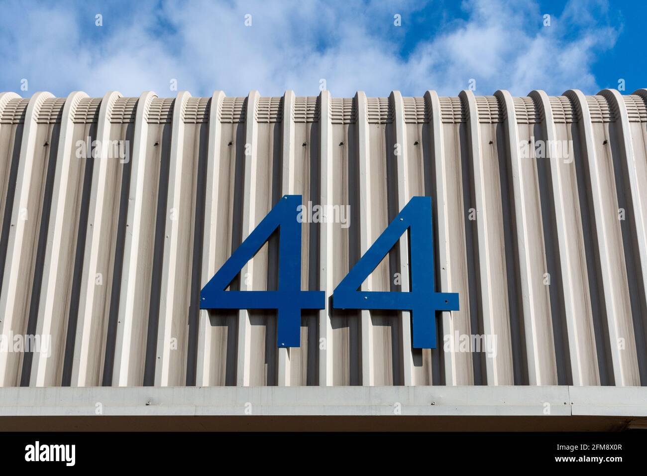 A large blue number 44 on a striped background with blue skies Stock ...