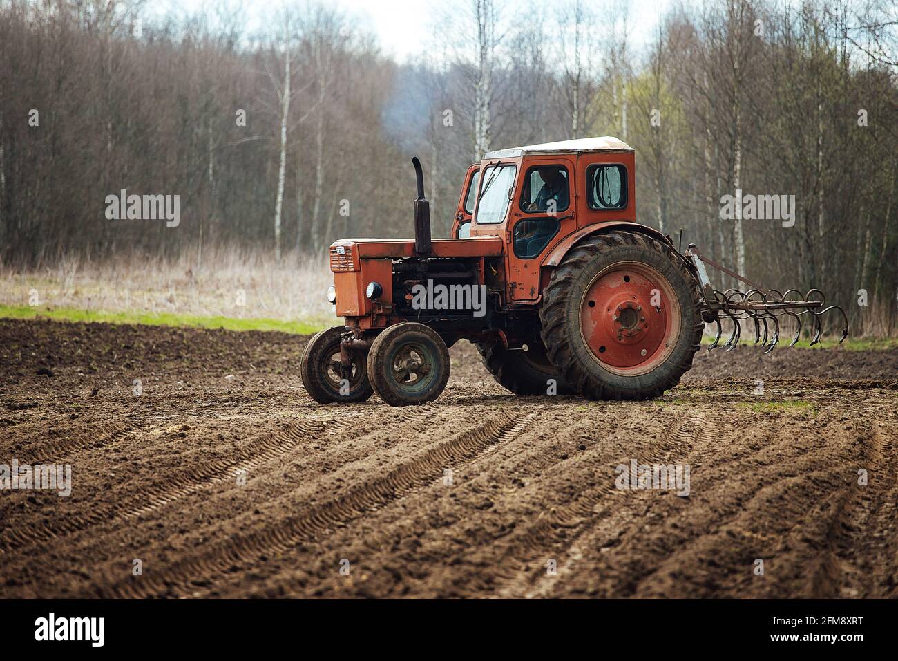 a tractor plows a field. preparation of agricultural land for planting ...