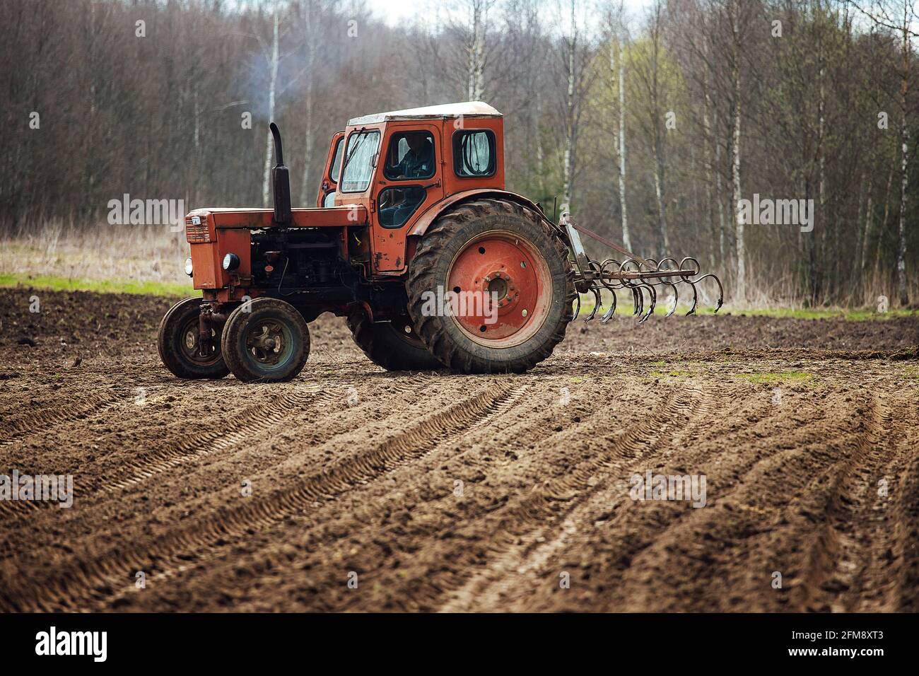 a tractor plows a field. preparation of agricultural land for planting ...