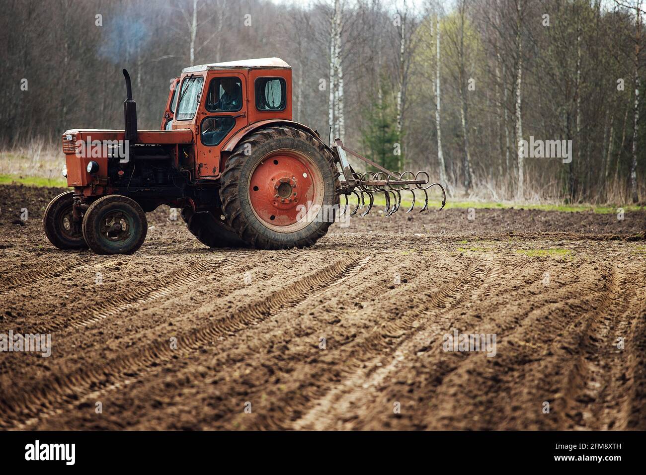 a tractor plows a field. preparation of agricultural land for planting ...