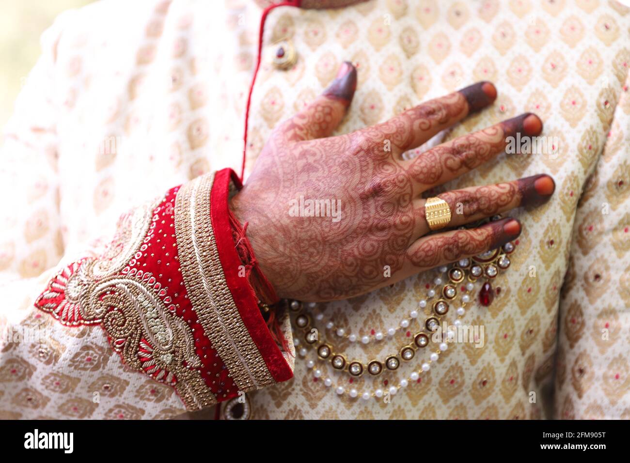Closeup of an Indian groom wearing Sherwani and accessories during the ...