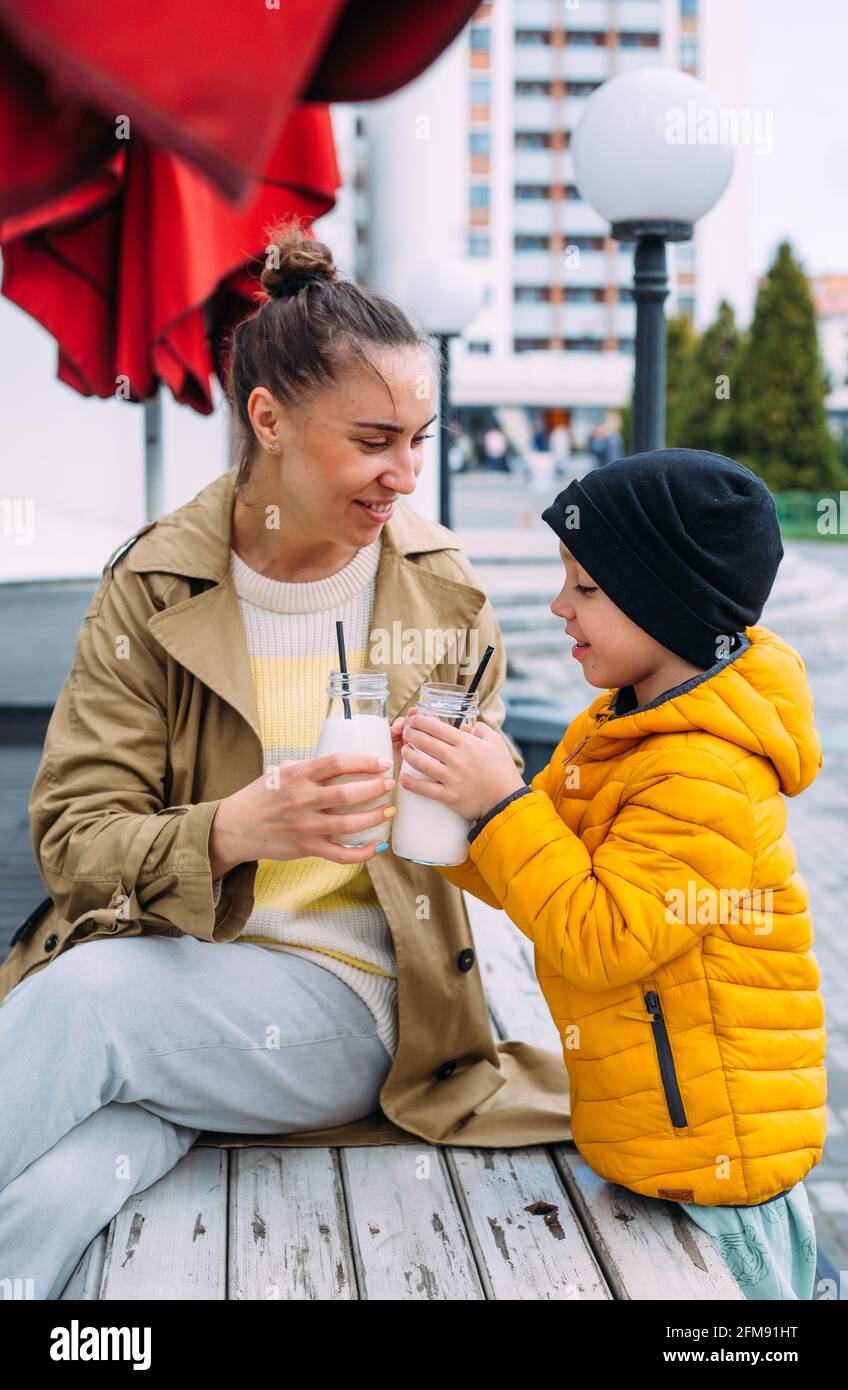Young mom and son have fun and drink milkshake outdoors Stock Photo - Alamy