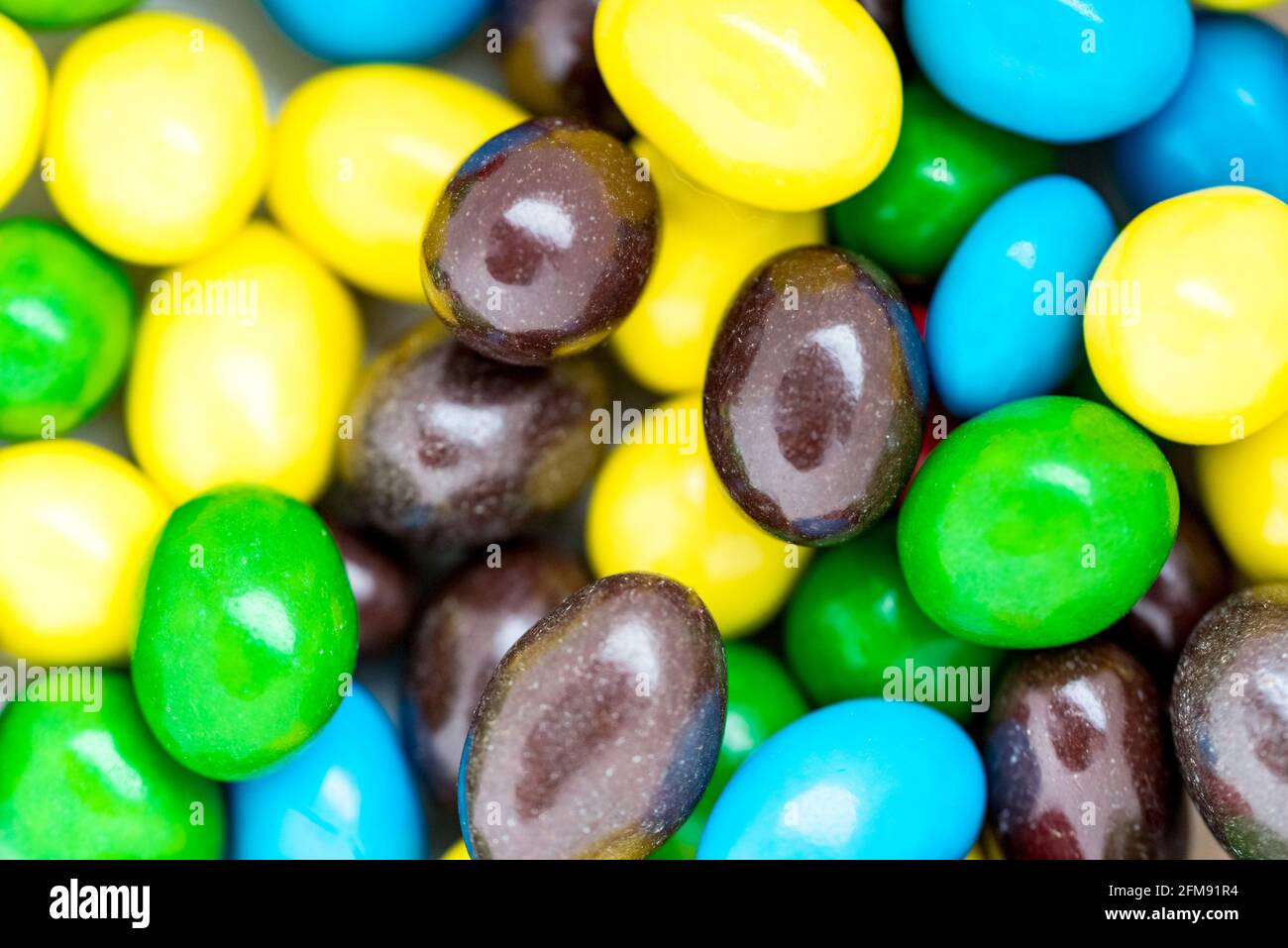 Colorful dragees, close-up on a white background. Chocolate candies in ...