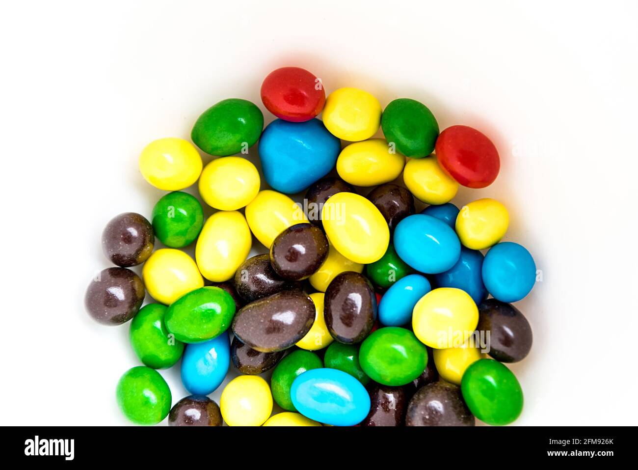 Colorful dragees, close-up on a white background. Chocolate candies in ...